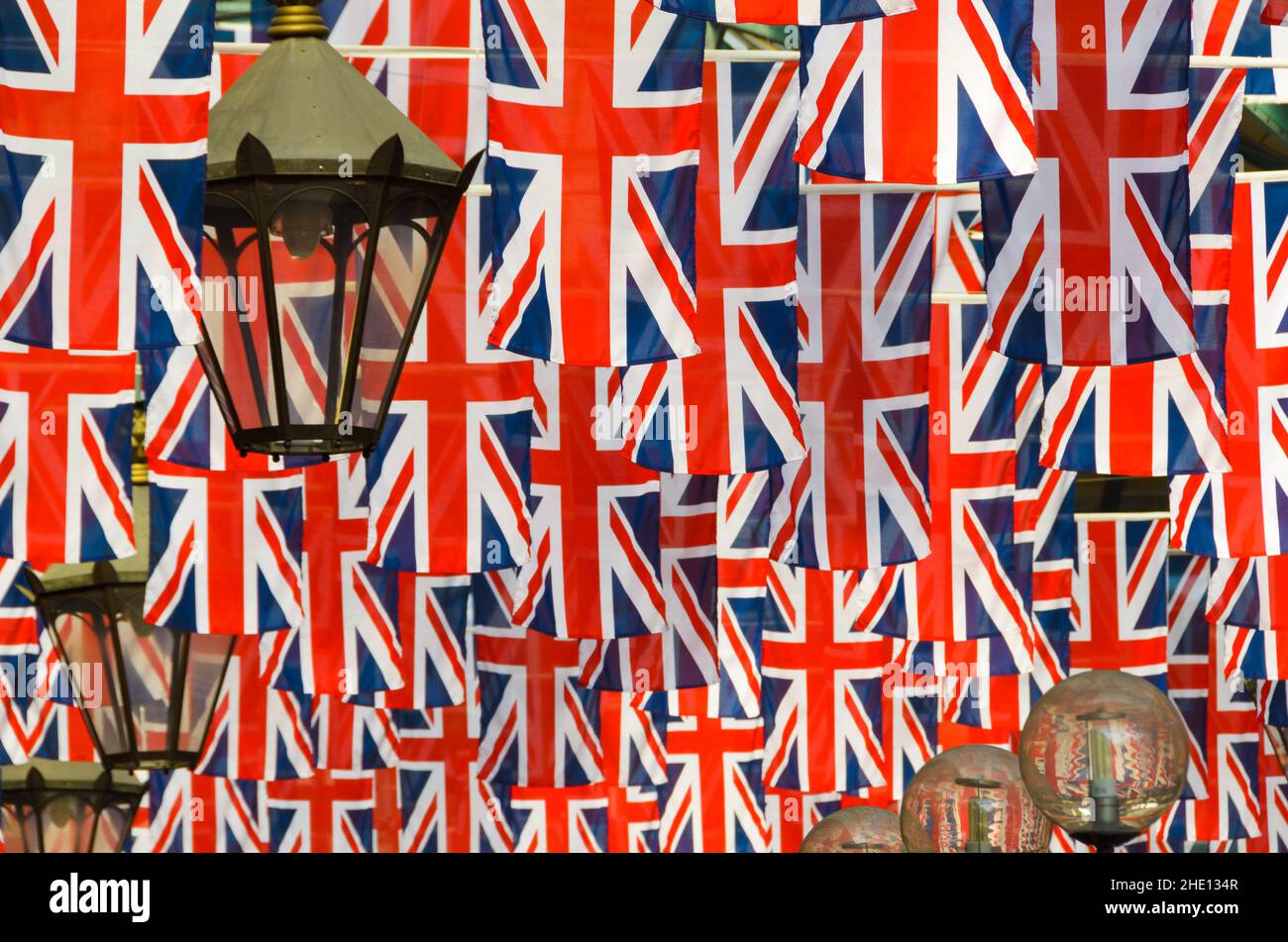 A large number of Union Jack flags hanging down among light fixtures ...