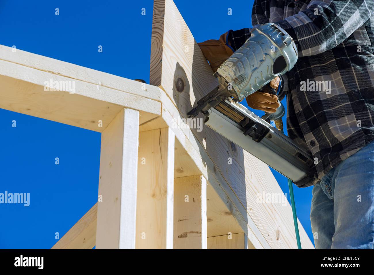 A carpenter for nailing wooden beam using an air hammer Stock Photo - Alamy