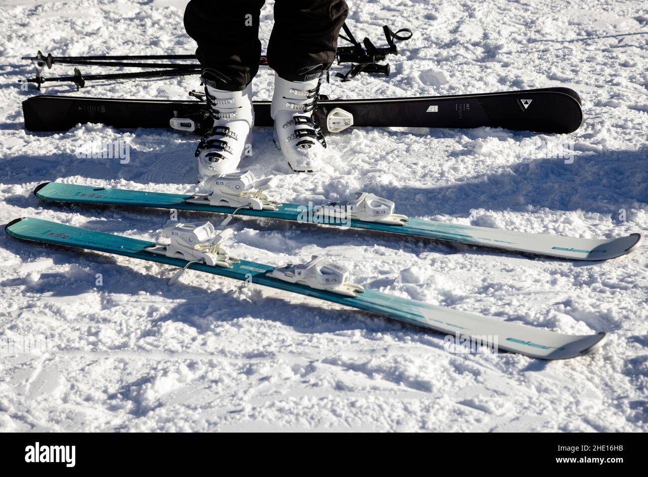 A skier in ski boots stands next to a pair of skis in Soriska planina ...