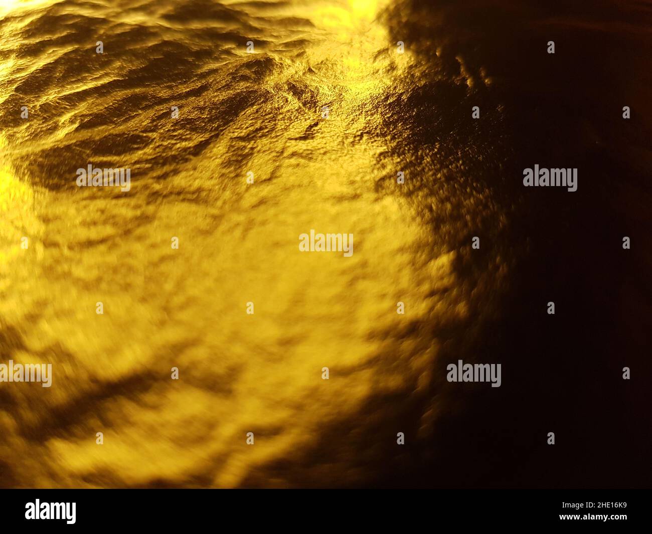 Golden shiny foil sheet close up background Stock Photo - Alamy
