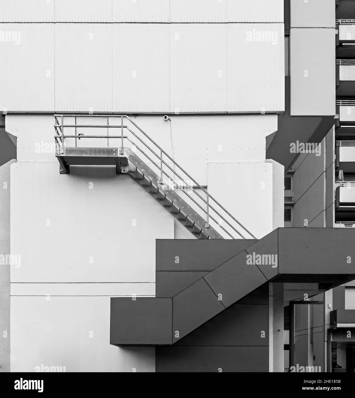 Grayscale of a Modern residential apartment building with metal raiing ...