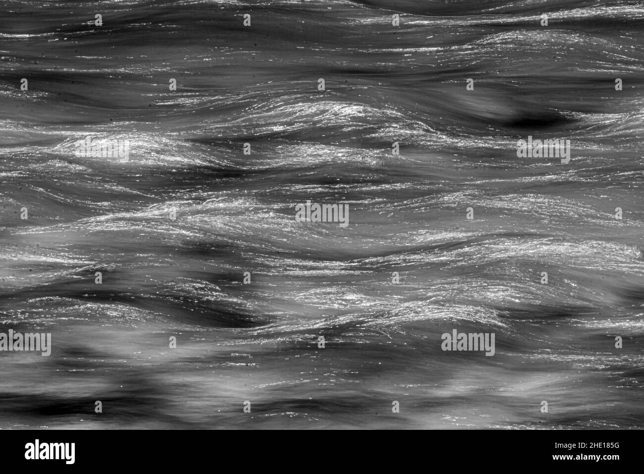 Grayscale of waves flowing water with random shadows on a sunny day ...