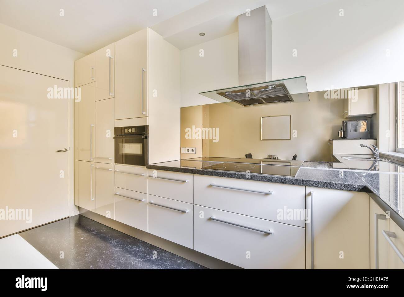 Comfortable kitchen with white kitchen unit and black countertop Stock ...