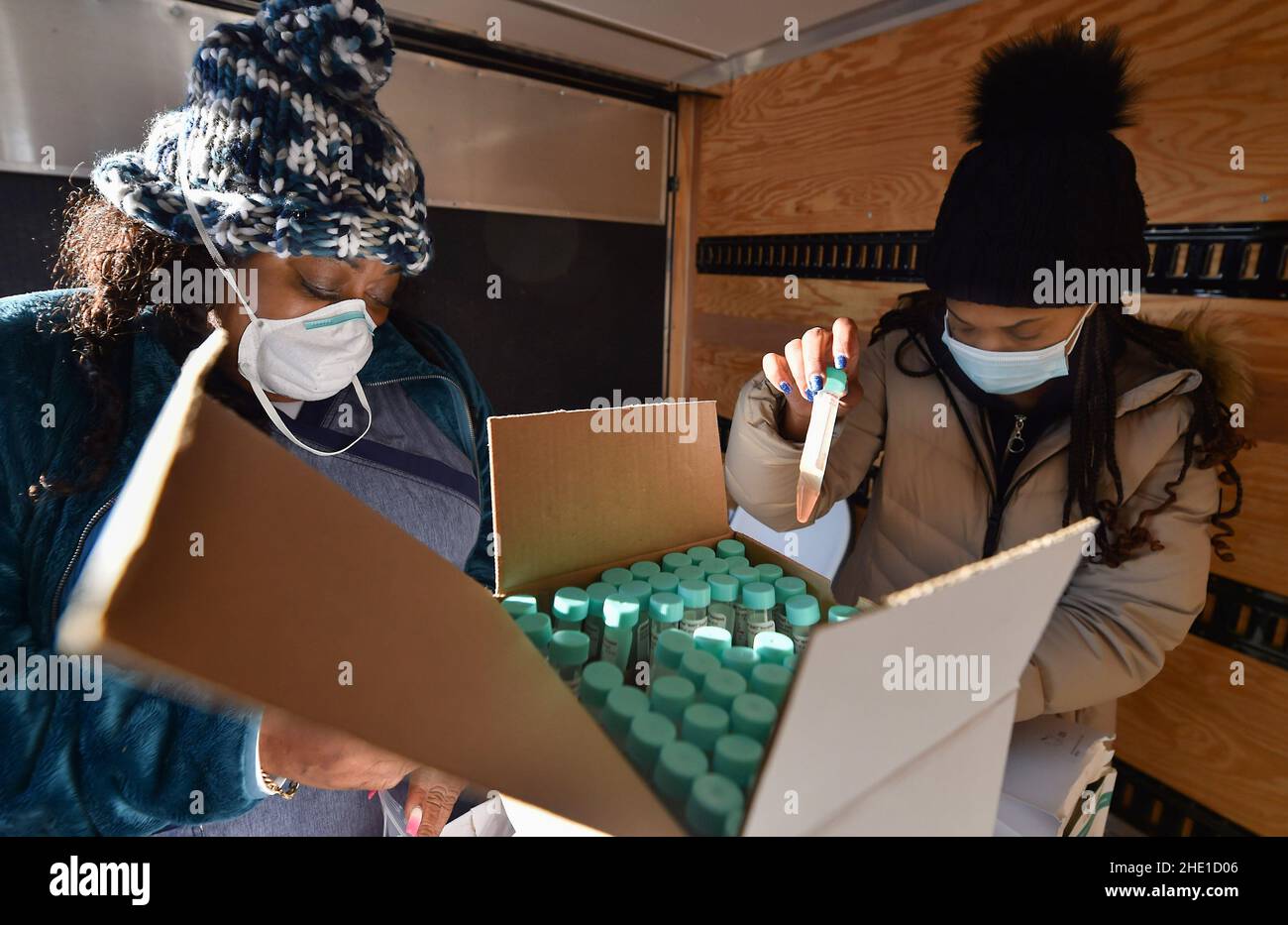 Health workers check all of the samples collected before storing them ...
