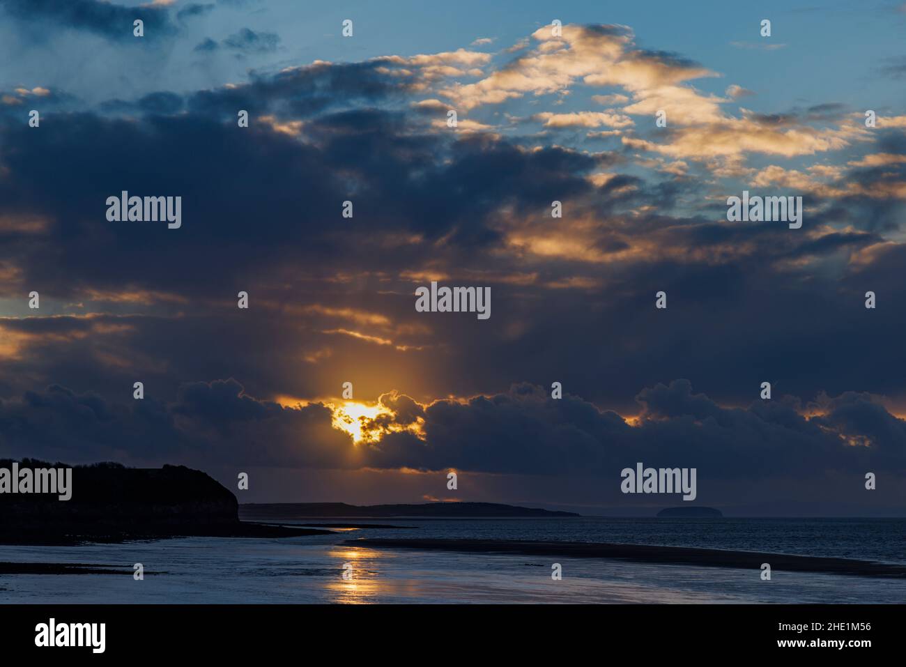 The setting sun lighting up the cloud cover Stock Photo - Alamy