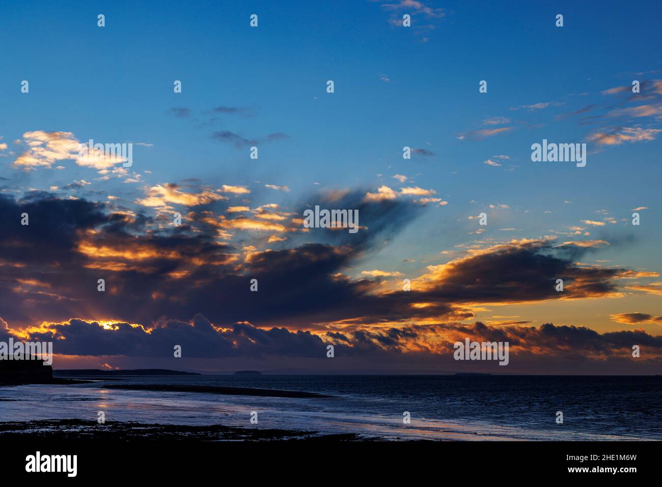 The setting sun lighting up the cloud cover Stock Photo - Alamy