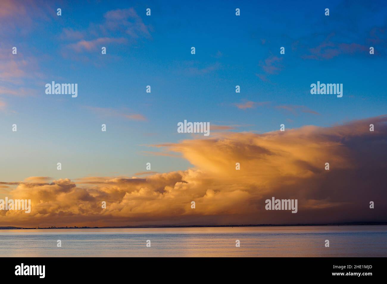 The setting sun lighting up the cloud cover Stock Photo - Alamy