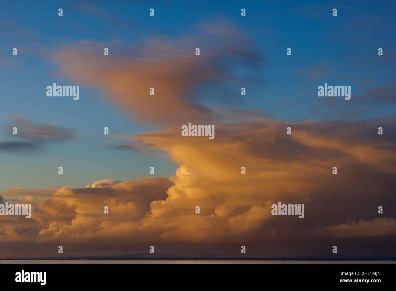 The setting sun lighting up the cloud cover Stock Photo - Alamy