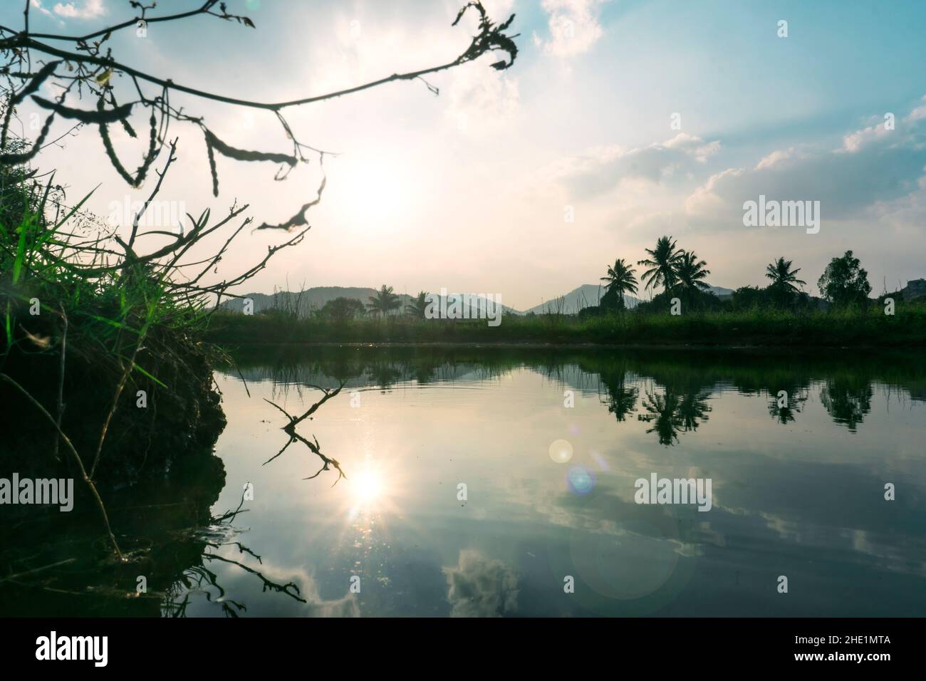 landscape picture of the sun setting over a lake and mountains Stock ...