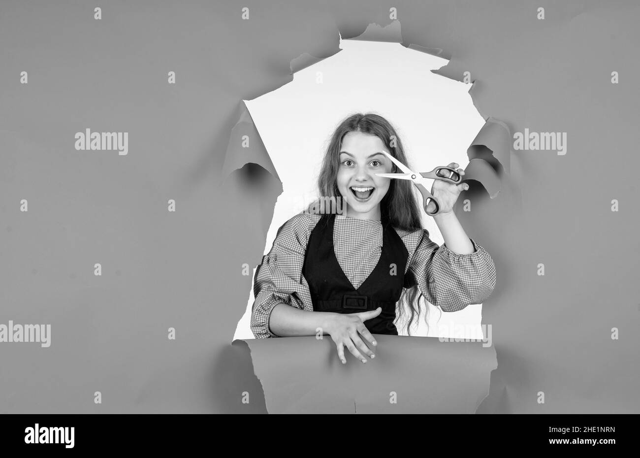 kid is trimmed in the hairdressers. child with scissors wants to cut ...