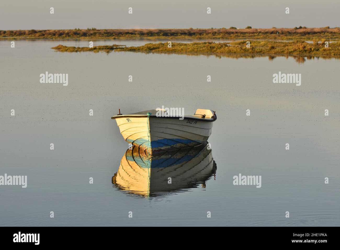 Fishing boat reflecting in saline lake at dawn, Faro Algarve Portugal ...