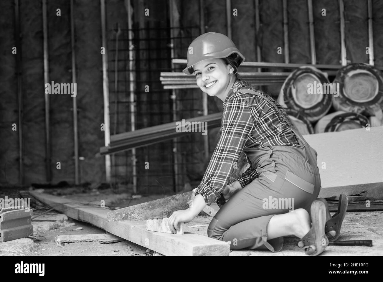 kid sawing a plank in carpentry. working with wood in a garage. happy ...