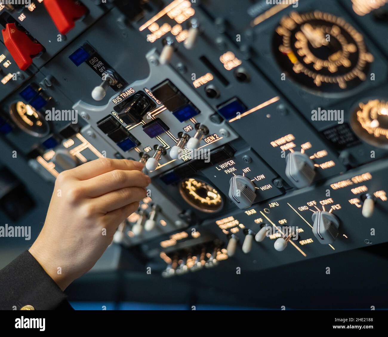 Close-up of a pilot's hand turning a toggle switch on the control panel ...