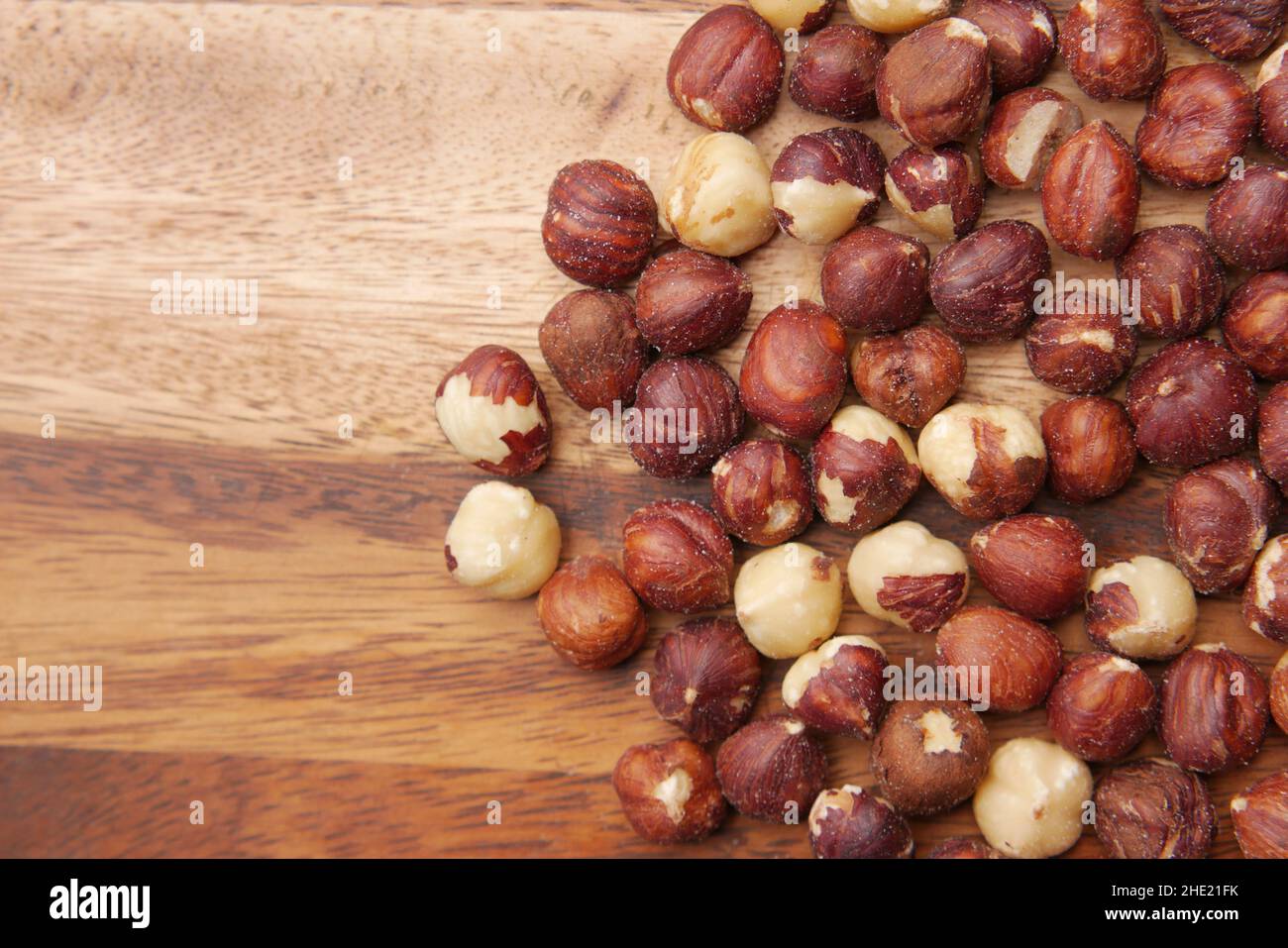 hazelnuts in a container on black background Stock Photo - Alamy