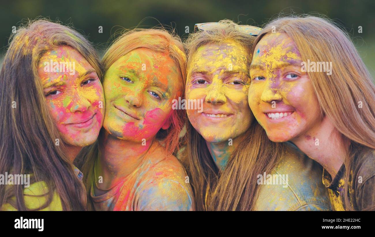 Cheerful girls posing smeared in multi-colored powder Stock Photo - Alamy
