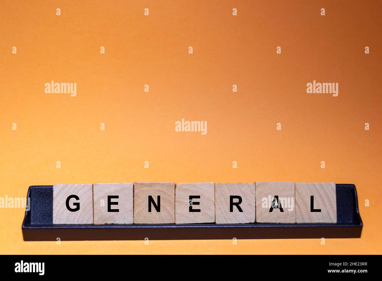 GENERAL. Word written on square wooden tiles with an orange background ...