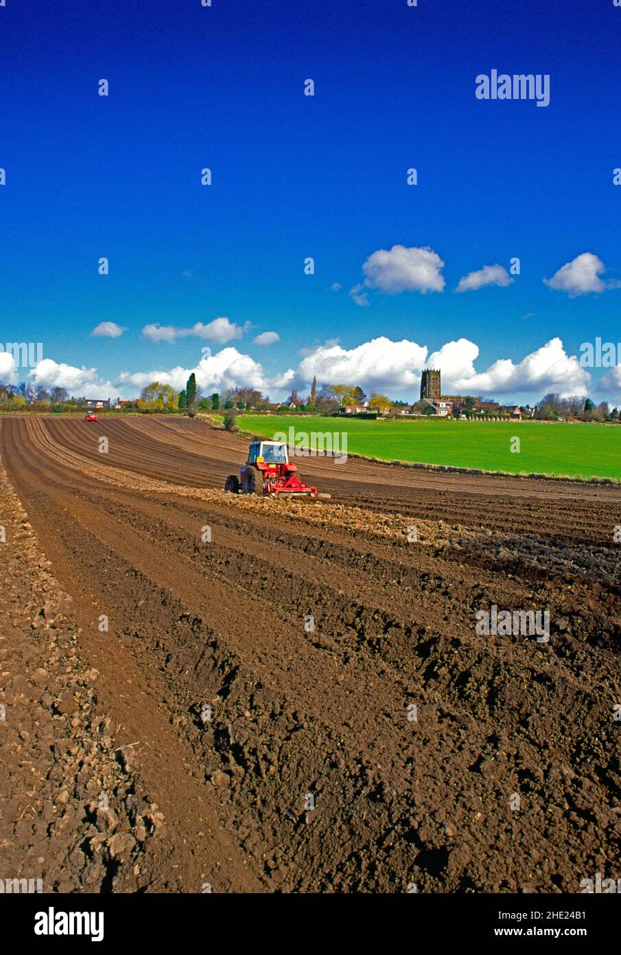 spring ploughing, with village church, UK Stock Photo - Alamy