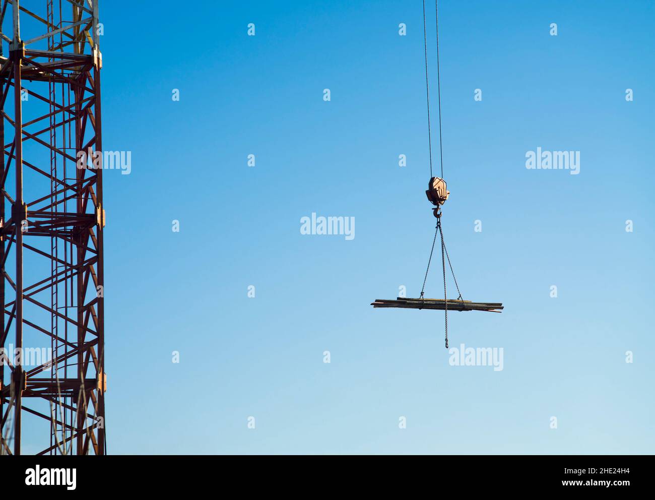 Construction crane hook with a cargo lifted in the air Stock Photo - Alamy