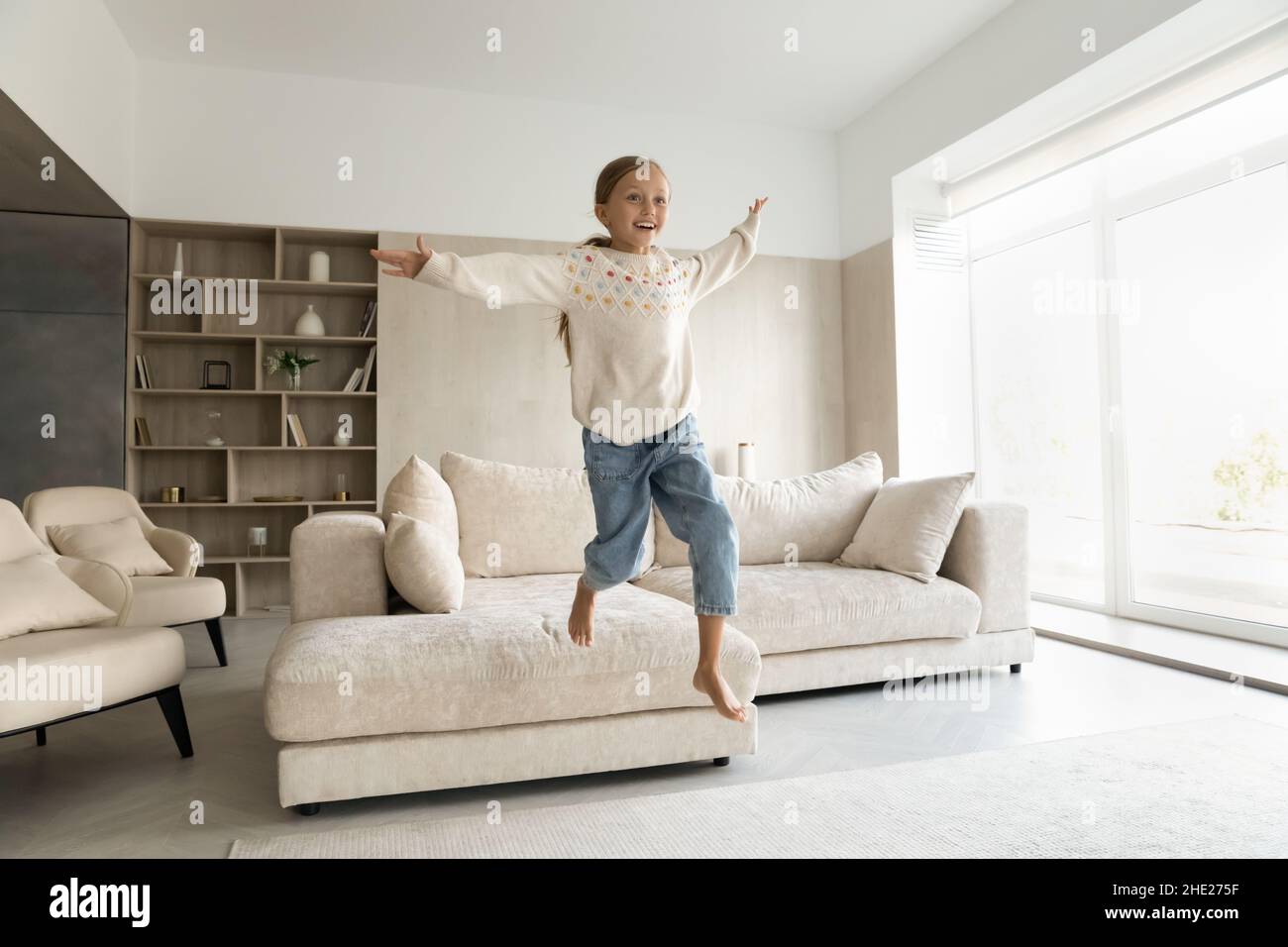 Happy little child girl jumping at home Stock Photo - Alamy
