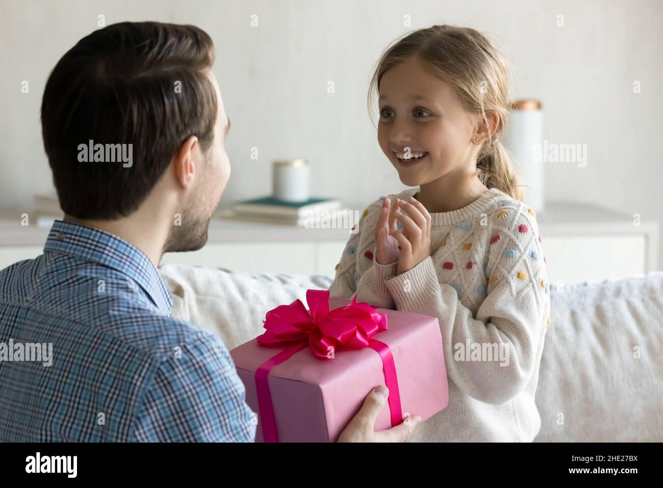 Surprised small girl feeling excited getting gift Stock Photo - Alamy