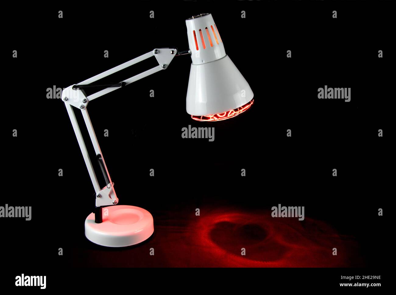 Illuminated infra red health lamp isolated on a black background Stock ...