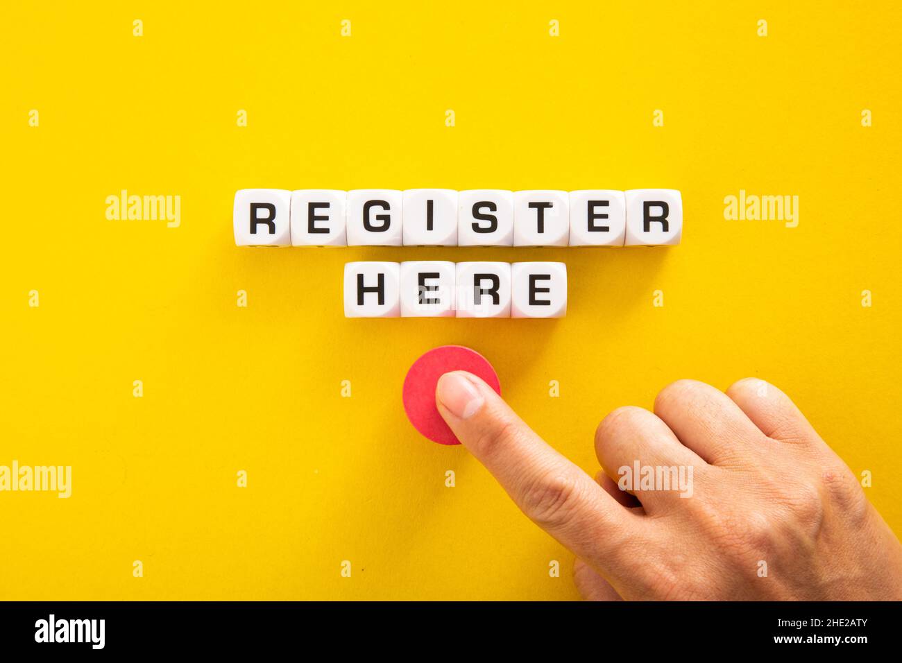 Hand pushing button with Register Here word Stock Photo - Alamy
