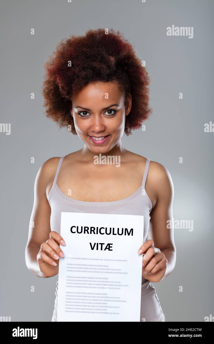 Smiling friendly young Black female job applicant holding her CV over a ...