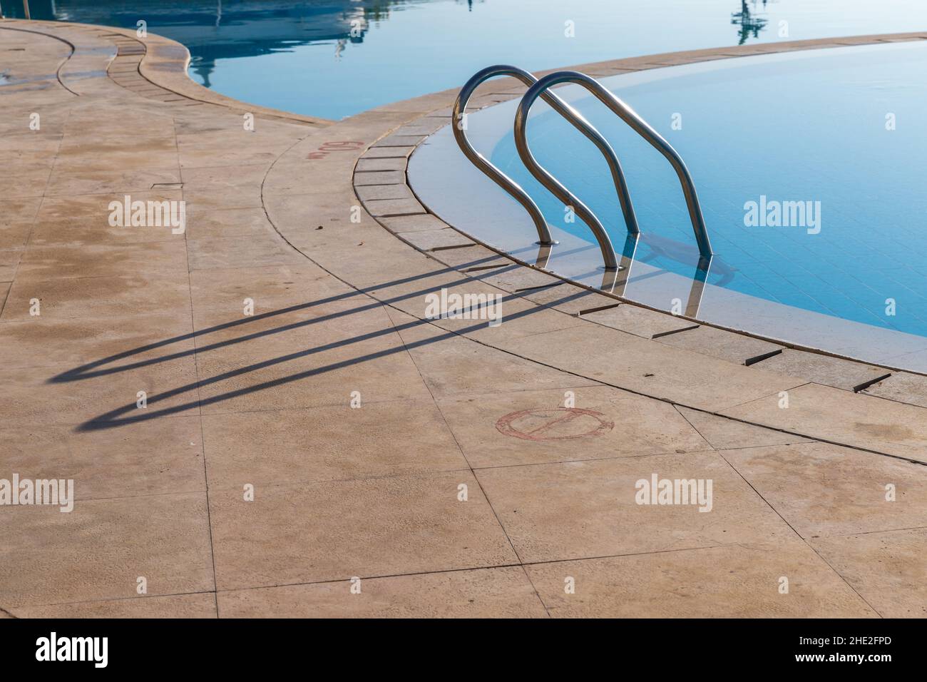 Railings of an outdoor swimming pool with blue water Stock Photo - Alamy