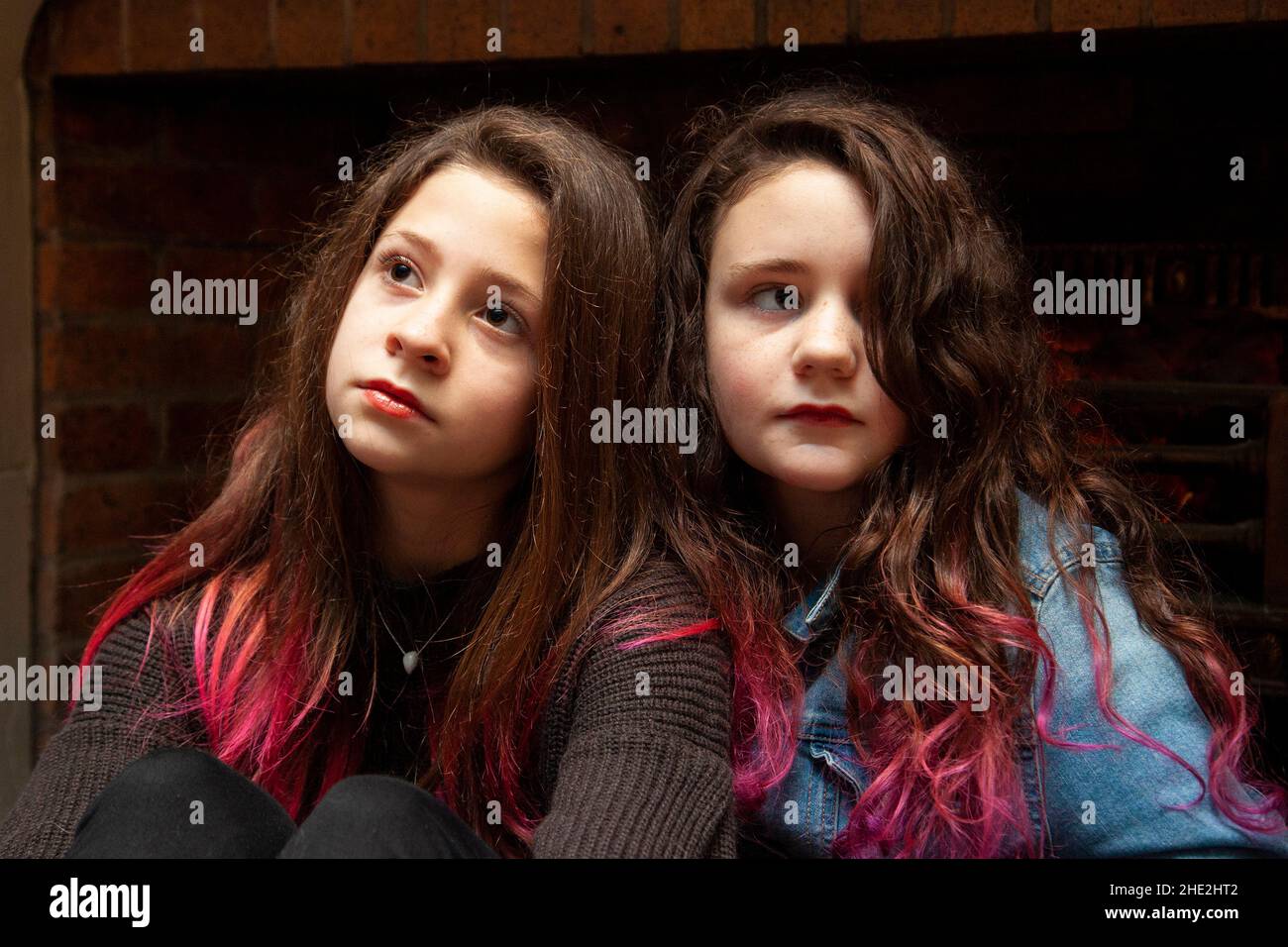 two young girls looking sad, emo or scared in front of a fireplace ...