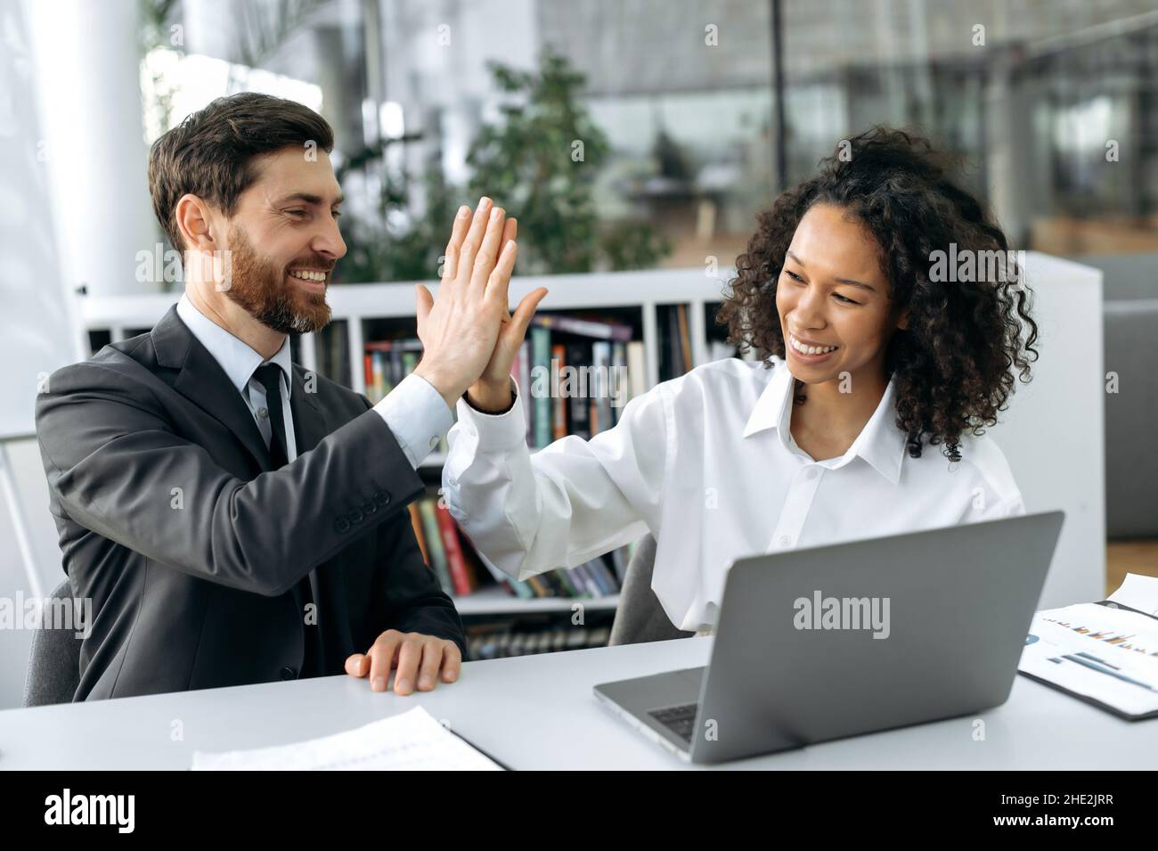 Good deal. Great job. Two successful multi-ethnic colleagues work in a ...