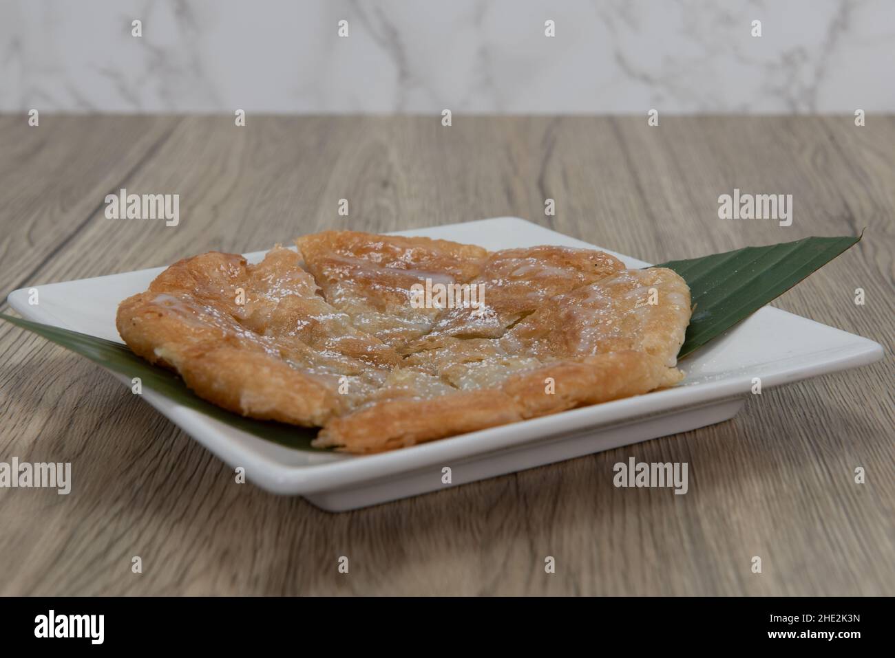 Dessert is served on the table with sweet roti in circular shape and ...