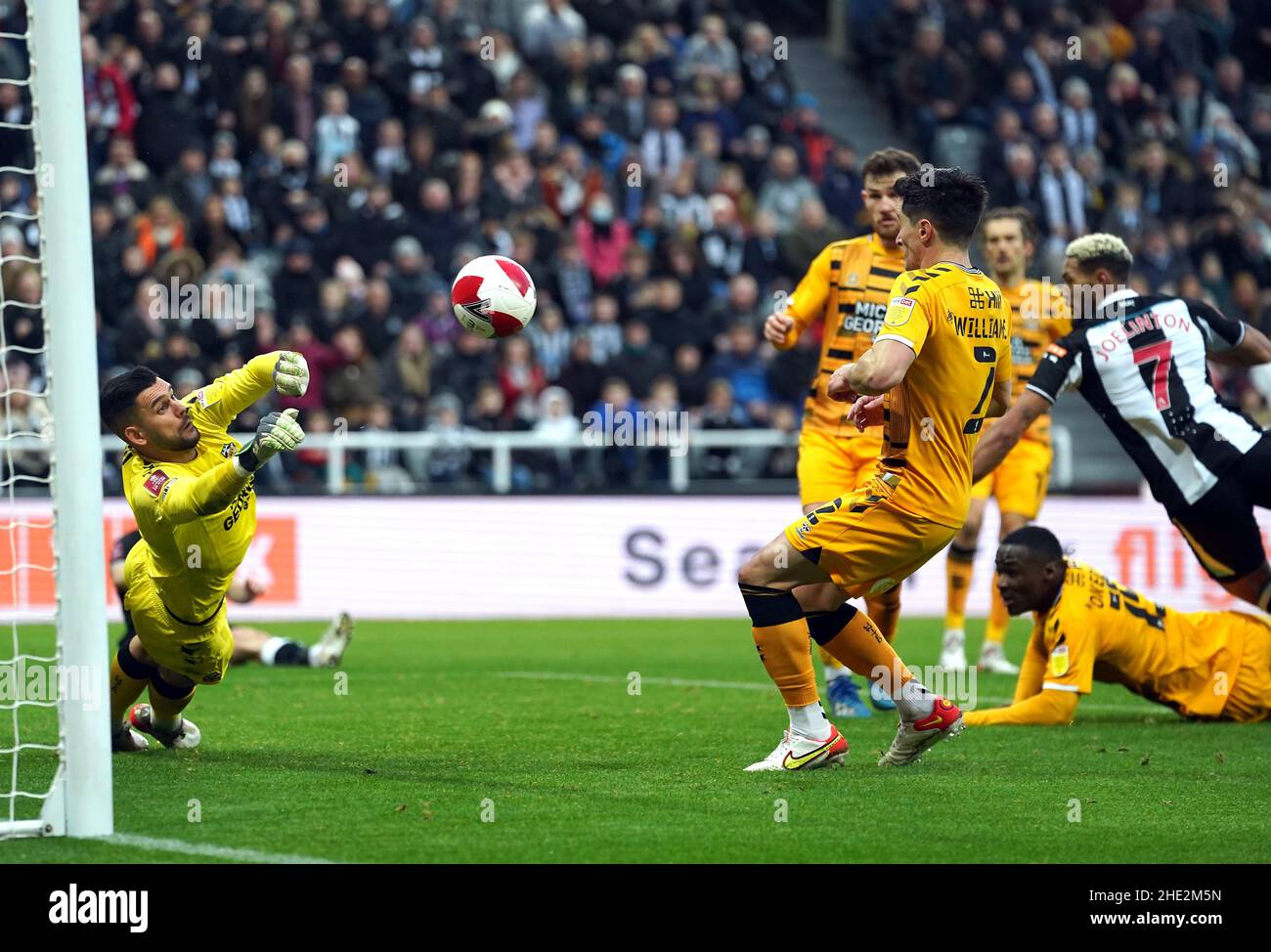 Cambridge United goalkeeper Dimitar Mitov (left) makes a save from ...
