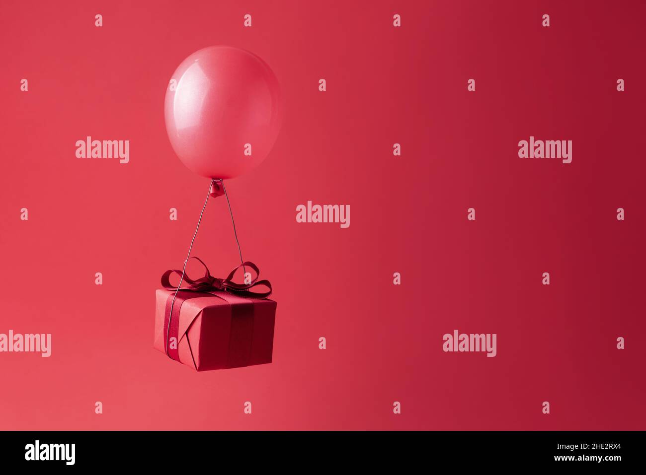Present flying on a balloon on a red background, gift giving, Valentine ...