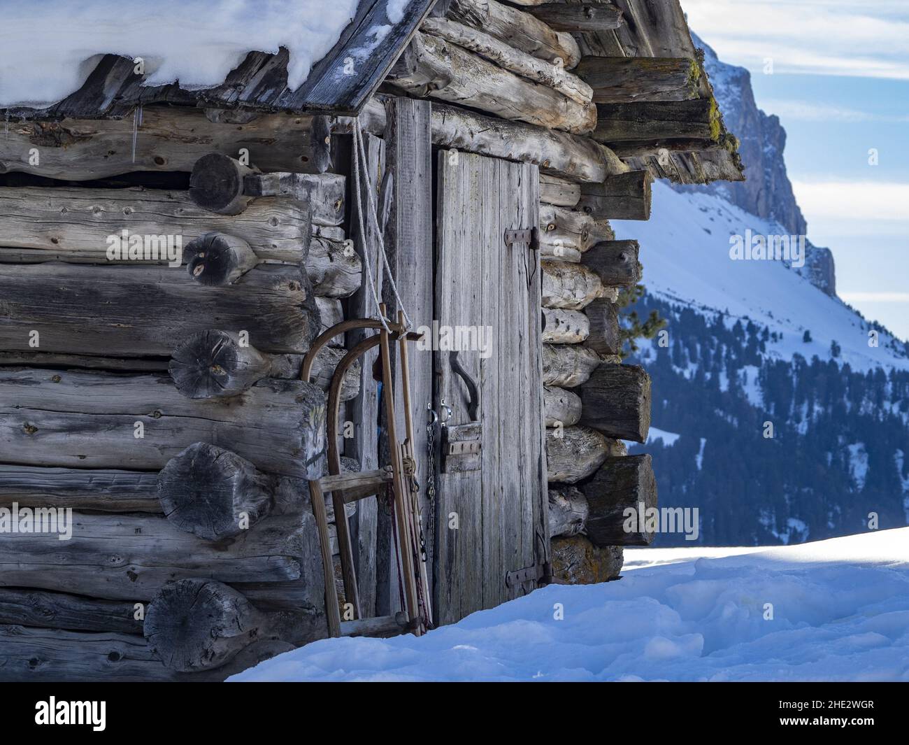 Snow sled outside wooden log cabin hut in winter season Stock Photo - Alamy