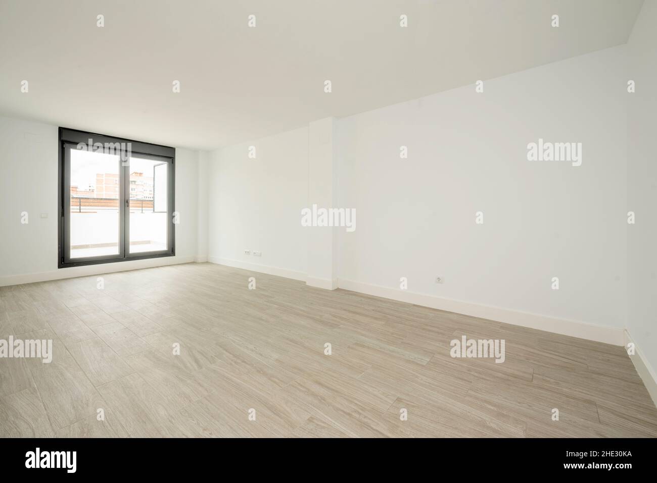 Empty white room with access to the terrace and wood-like ceramic tiles ...