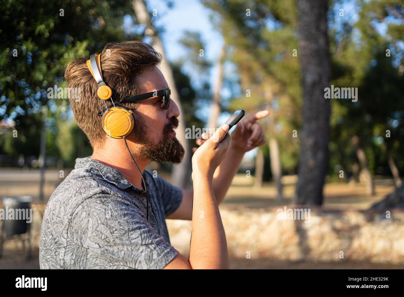 Profile of a man sending a voice message with his mobile phone while ...