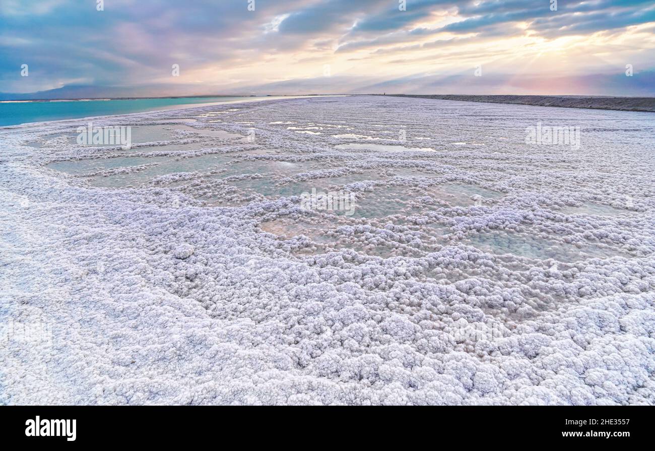 Crystalline white salt beach lit by morning sun, small pools with ...