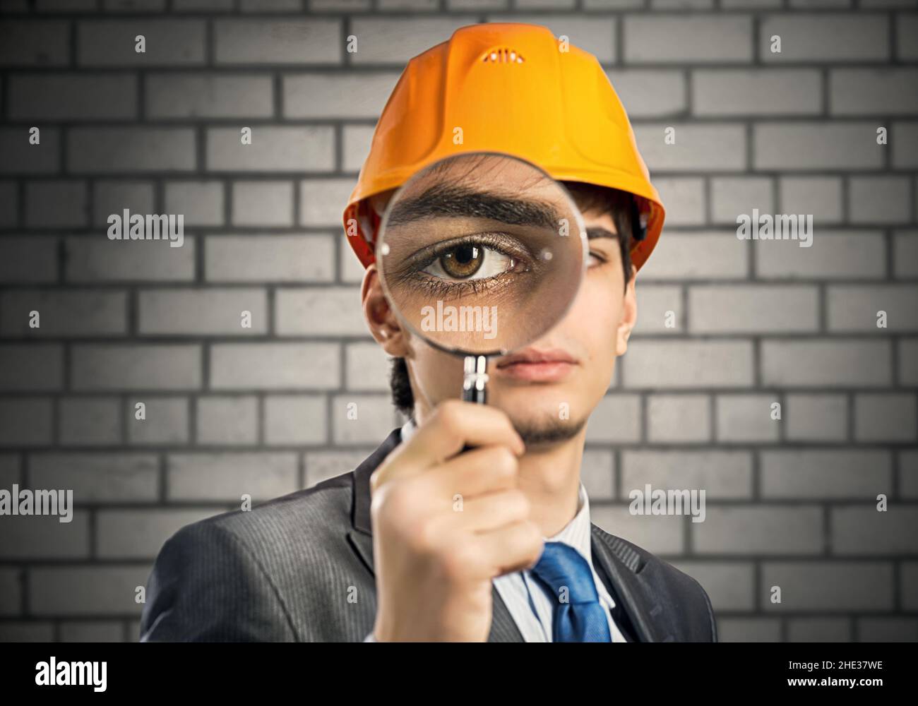 Construction man with magnifier Stock Photo - Alamy