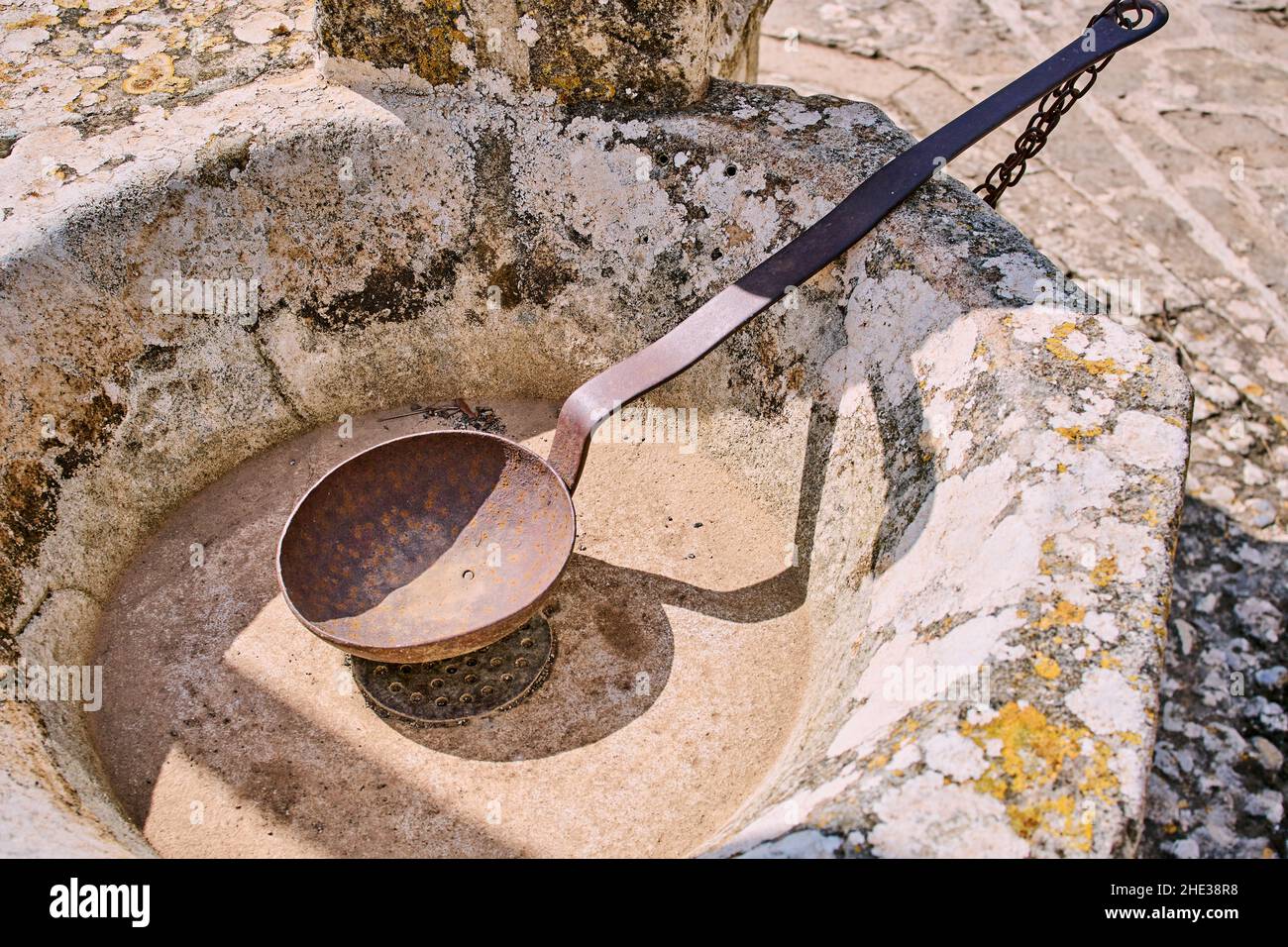 historical ladle in an old stone well Stock Photo - Alamy