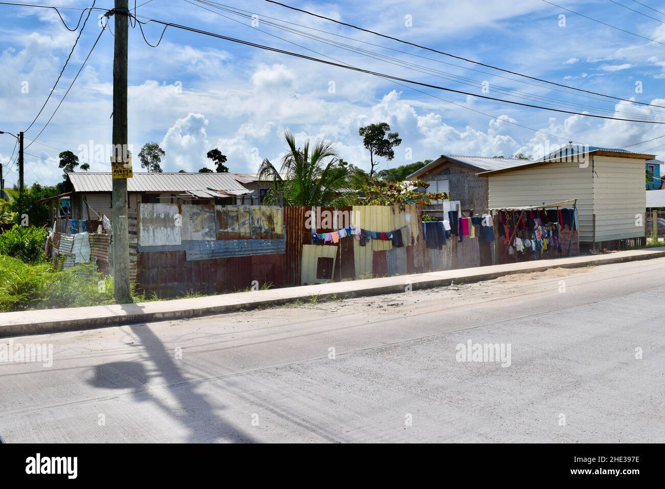 Clothes drying on a corrugated sheet fence in a poor neighborhood of ...