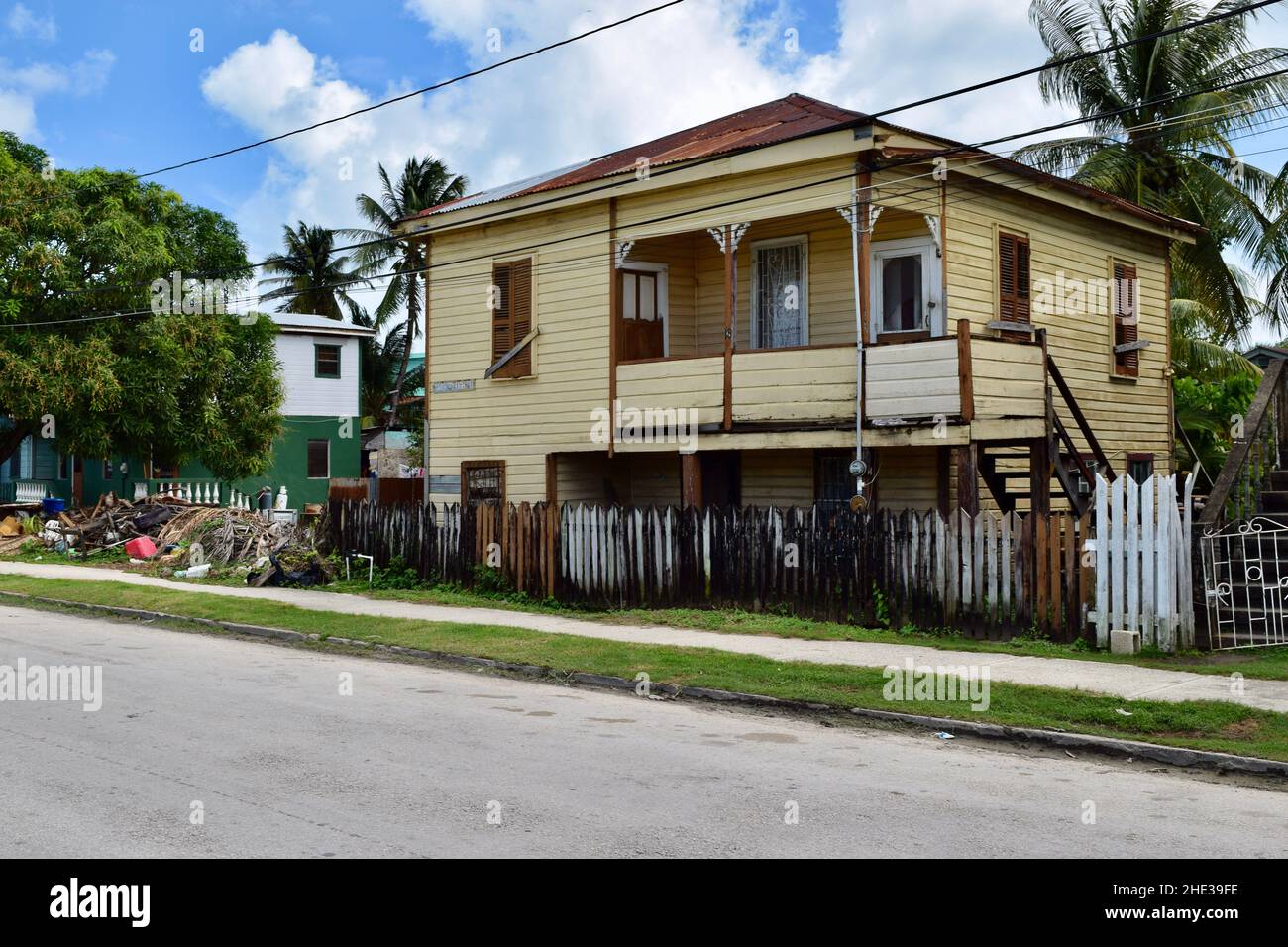 A yellow wooden house in need of repairs in a neighborhood of Belize ...
