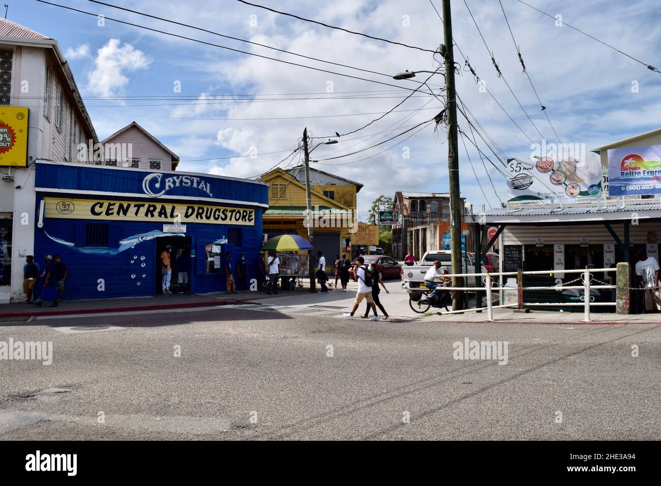 Belizeans standing in front of a drugstore and going about their ...