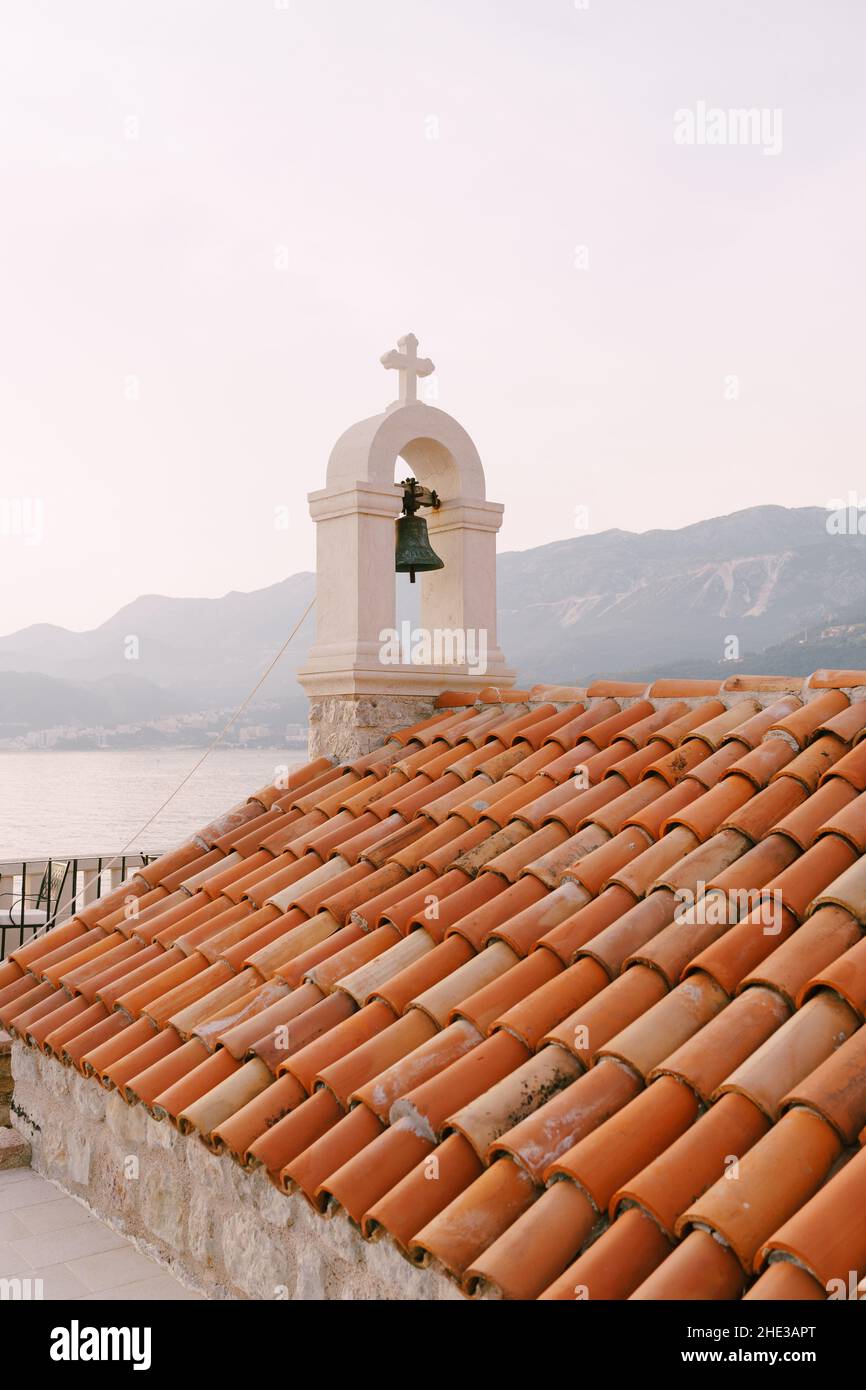 Bell on an old stone bell tower with a red tiled roof Stock Photo - Alamy