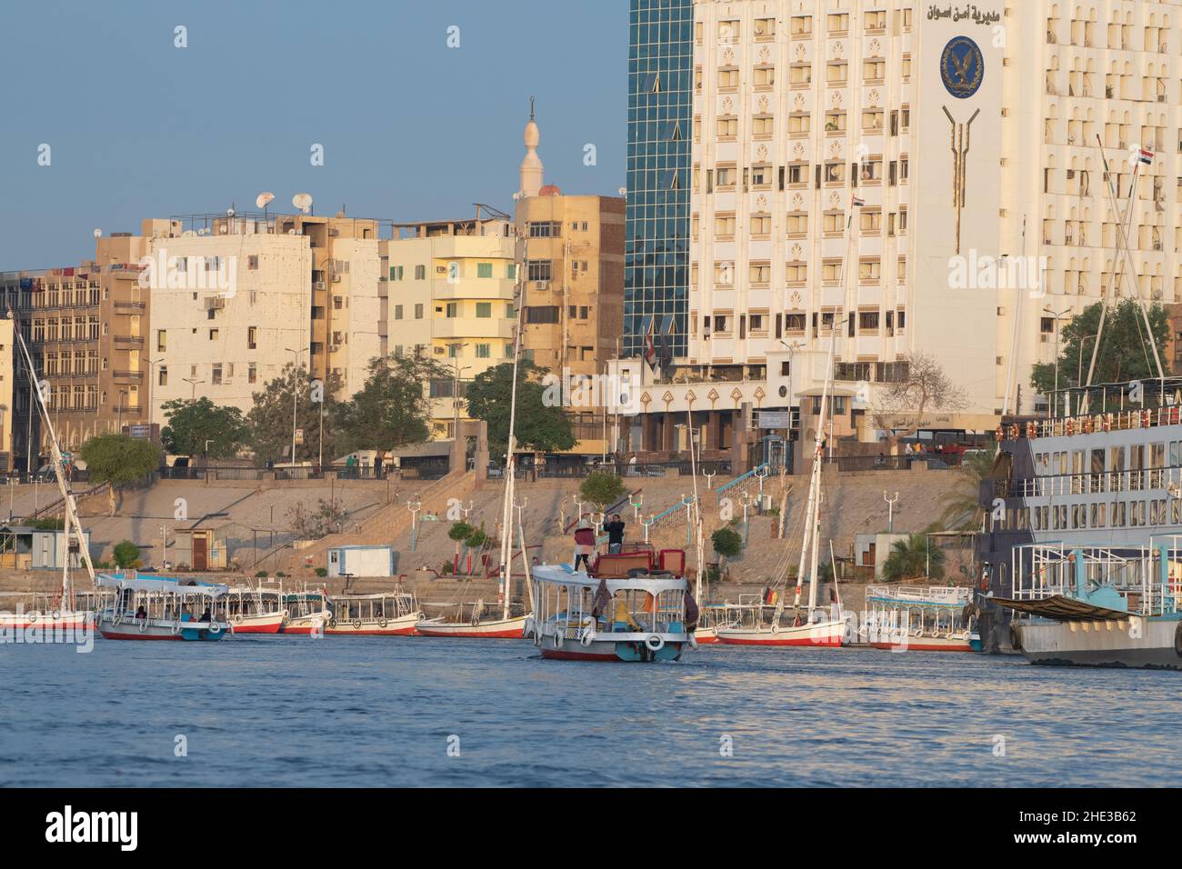 Boats docked along the edge of the Nile river in Aswan city in Southern ...