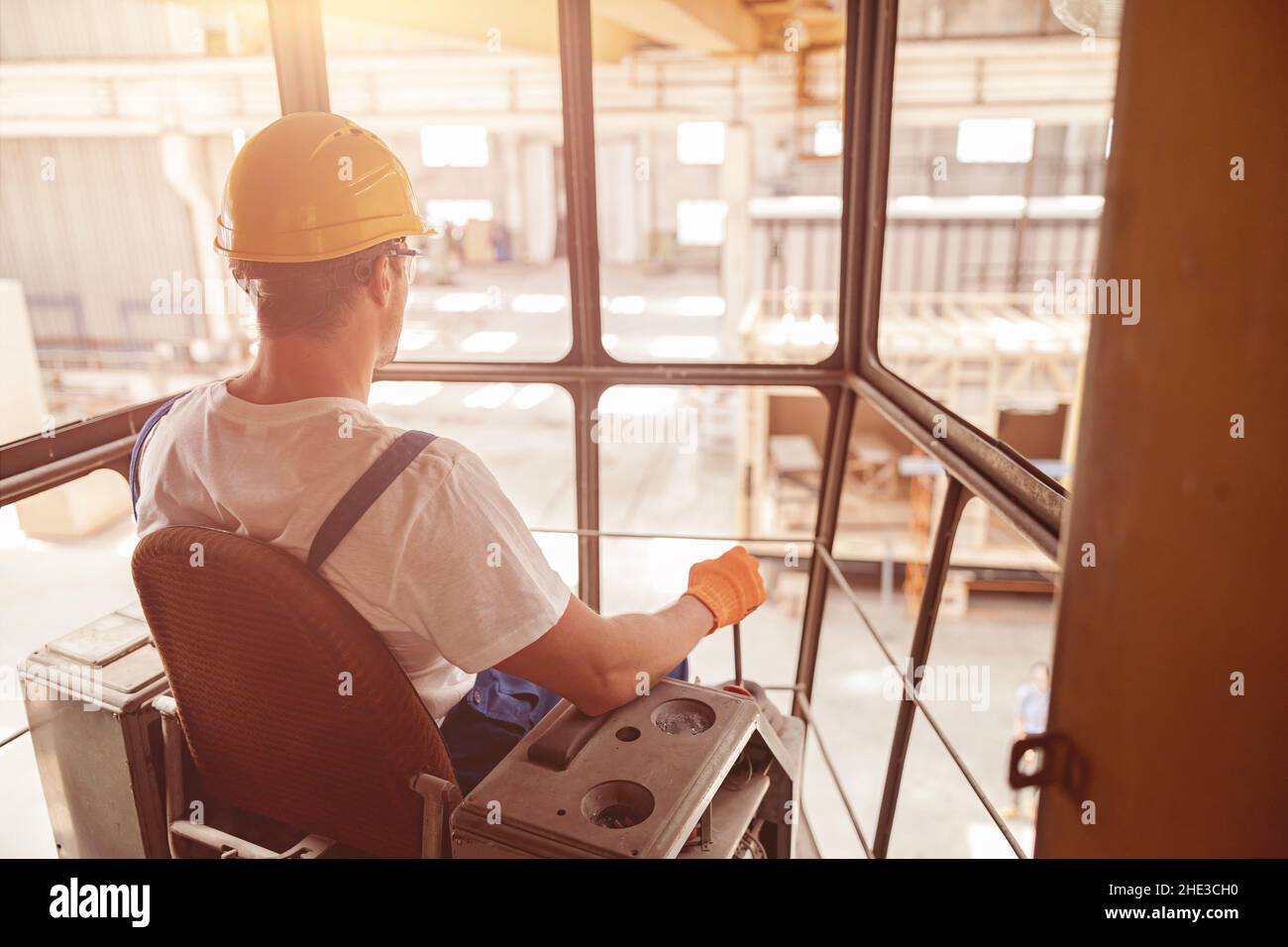 Male worker sitting in operator cabin of overhead crane Stock Photo - Alamy