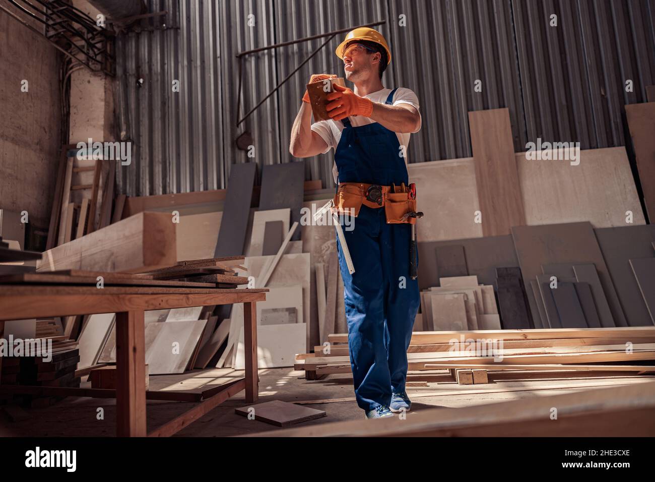 Male builder carrying timber wood plank at construction site Stock ...