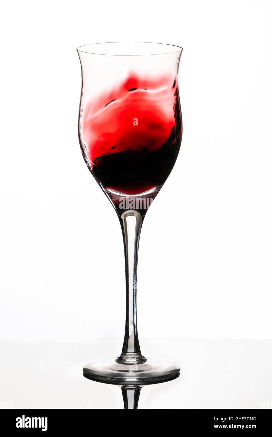 Swirl or movement of liquid in a glass of red wine. White background ...