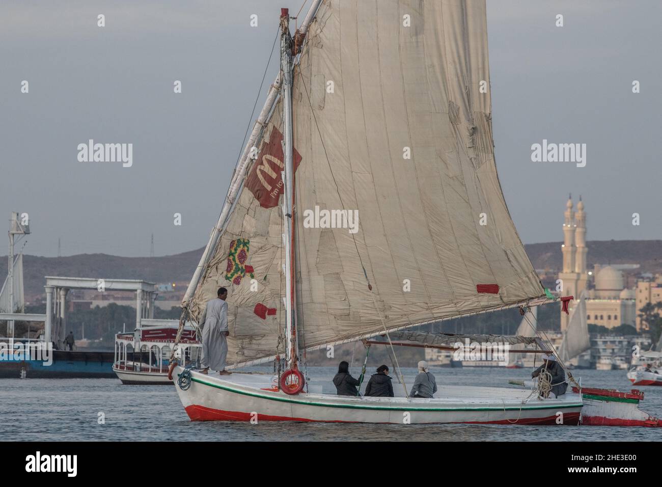 A Felucca boat with patched sails in the Nile river near Aswan city in ...