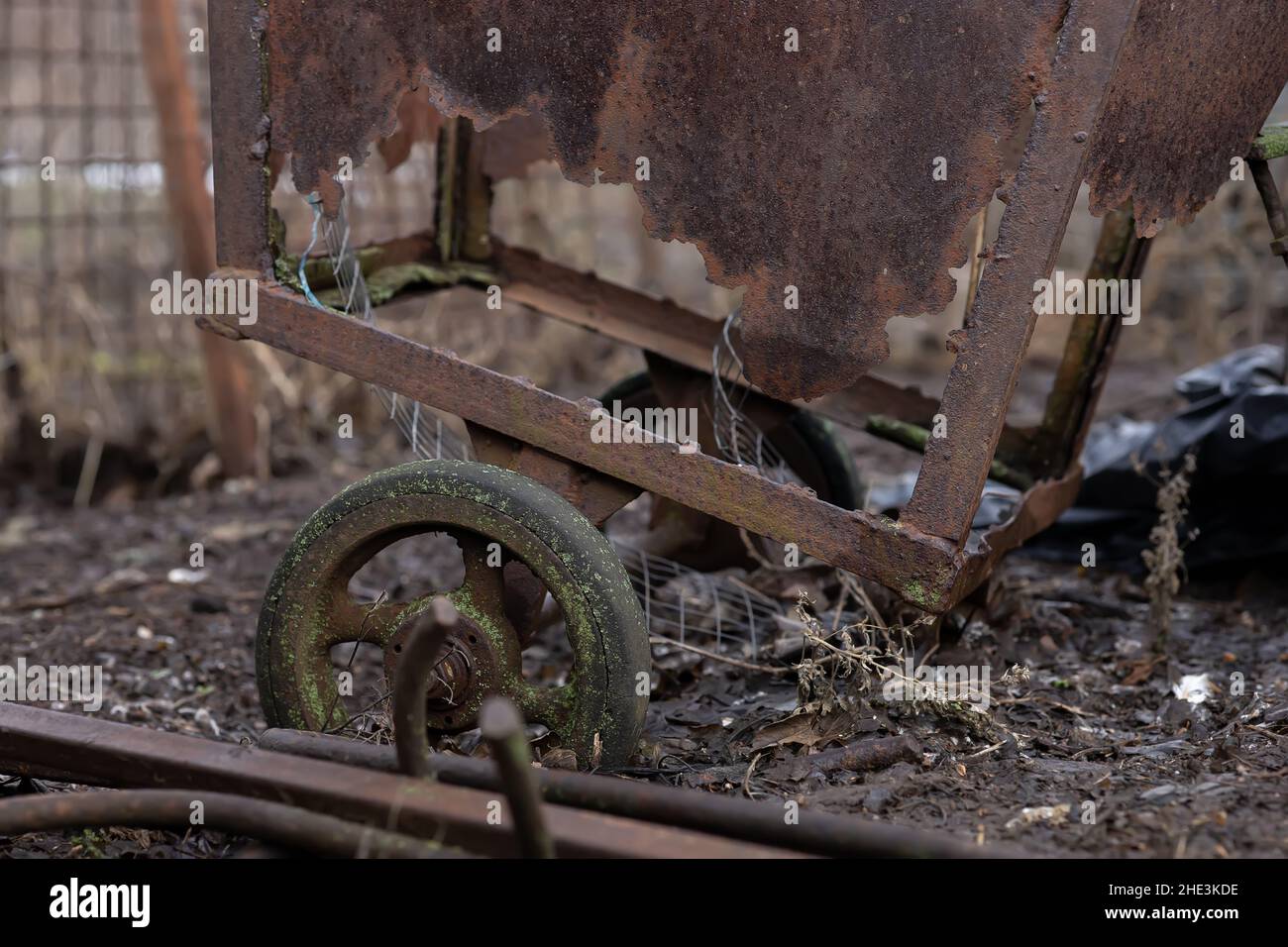 a wheel from an old rusty wheelbarrow of scrap metal Stock Photo - Alamy