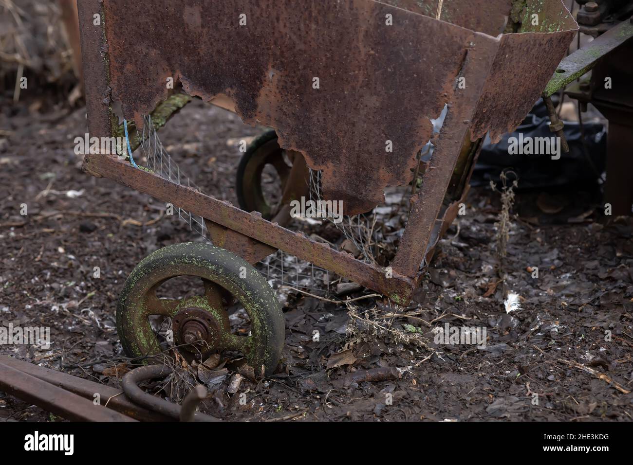 a wheel from an old rusty wheelbarrow of scrap metal Stock Photo - Alamy